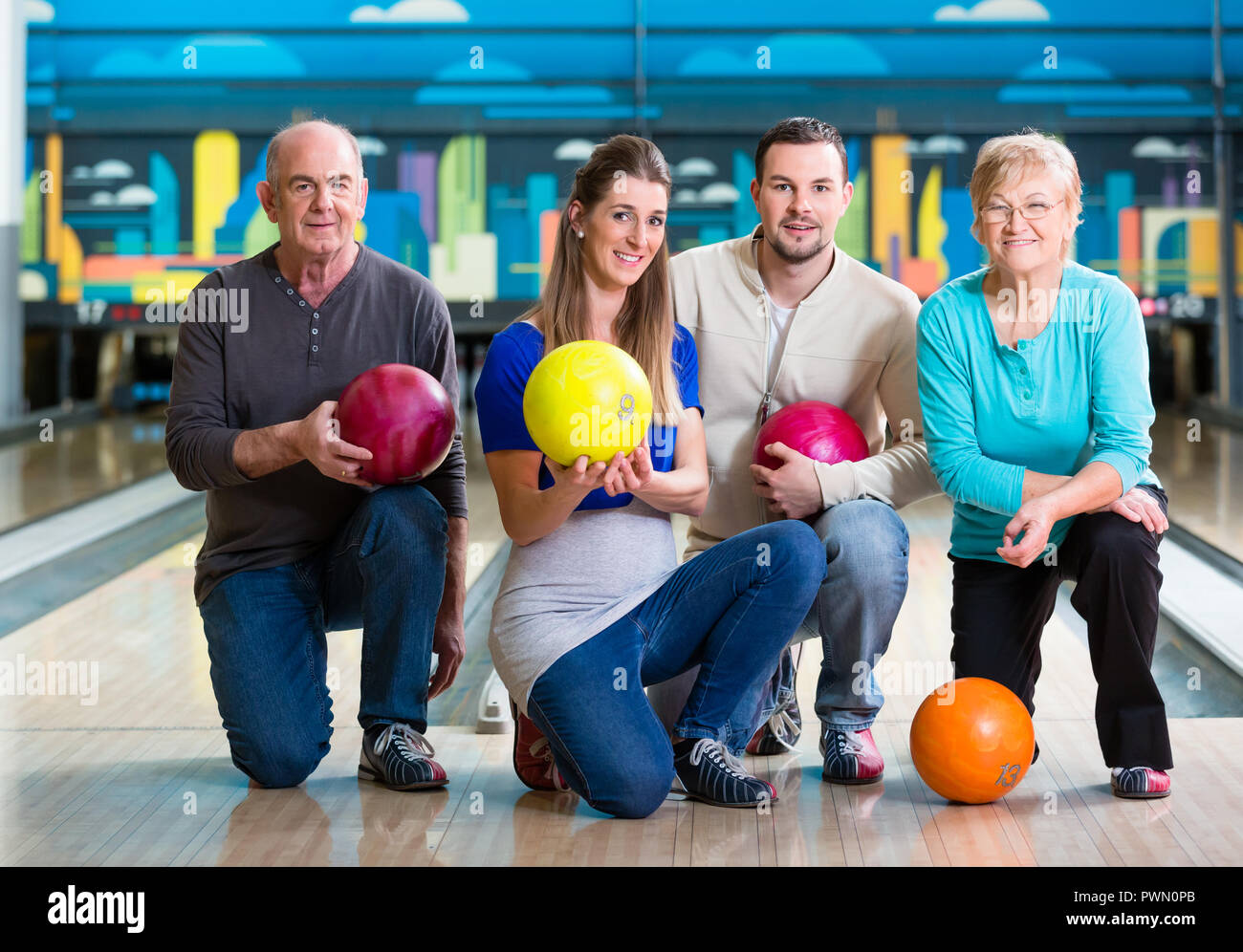 Family with multi colored bowling ball posing Stock Photo - Alamy