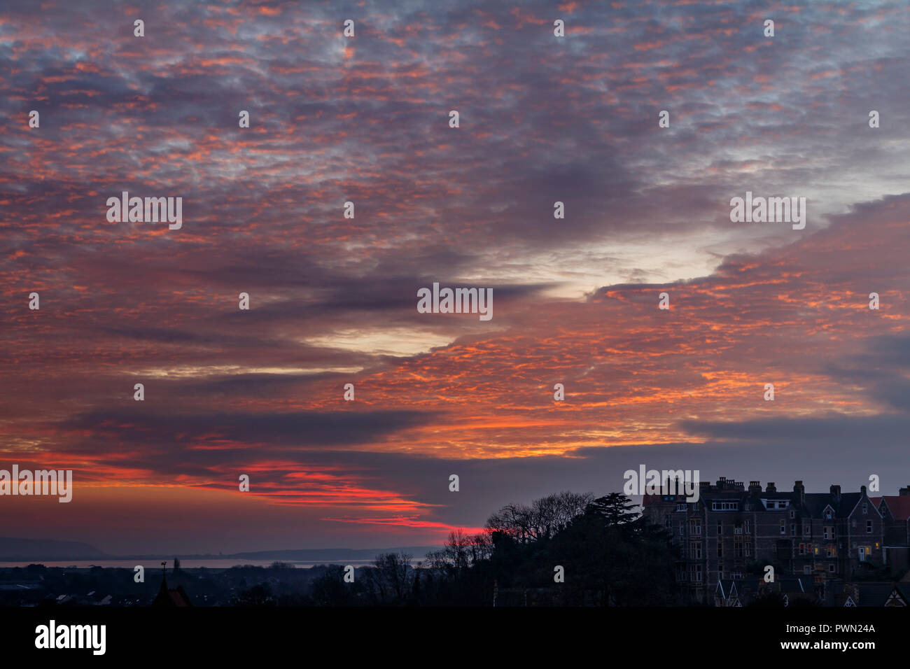 The setting sun lighting up the edge of the cloud-cover Stock Photo - Alamy