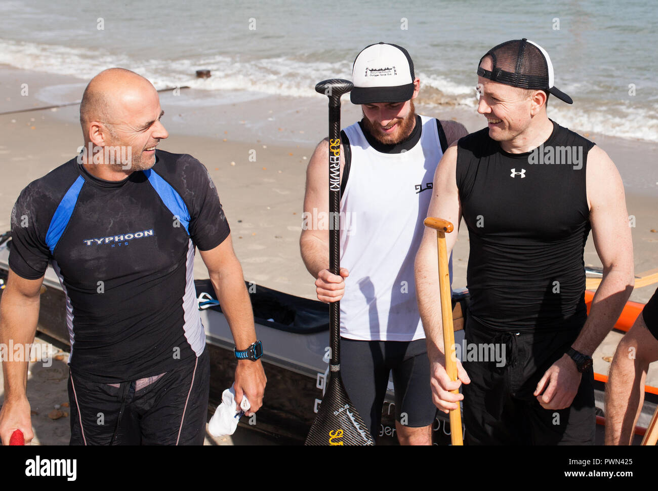 Men just finishing a Dragon boat race Stock Photo - Alamy