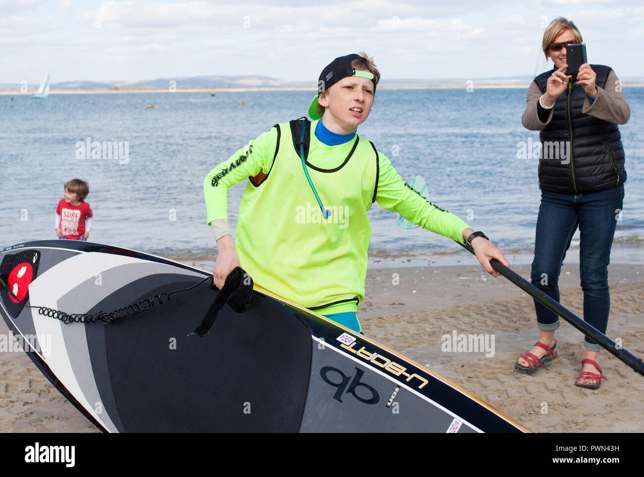 Teenager finishing a paddle board race Stock Photo - Alamy