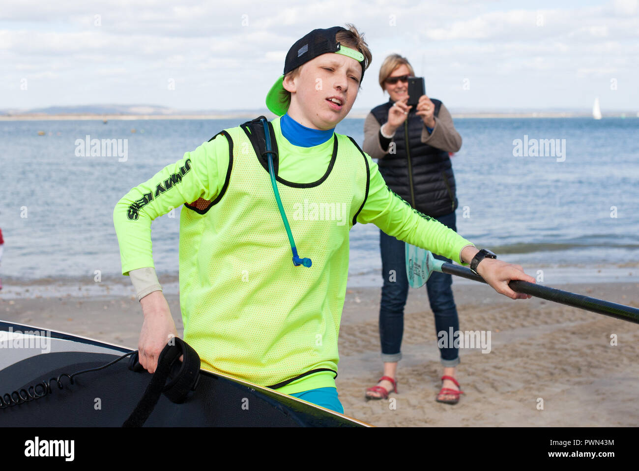 Teenager finishing a paddle board race Stock Photo - Alamy