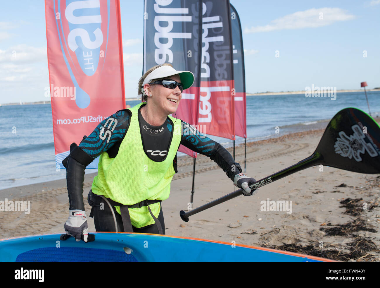 Woman walking with paddle board to a finish line Stock Photo - Alamy