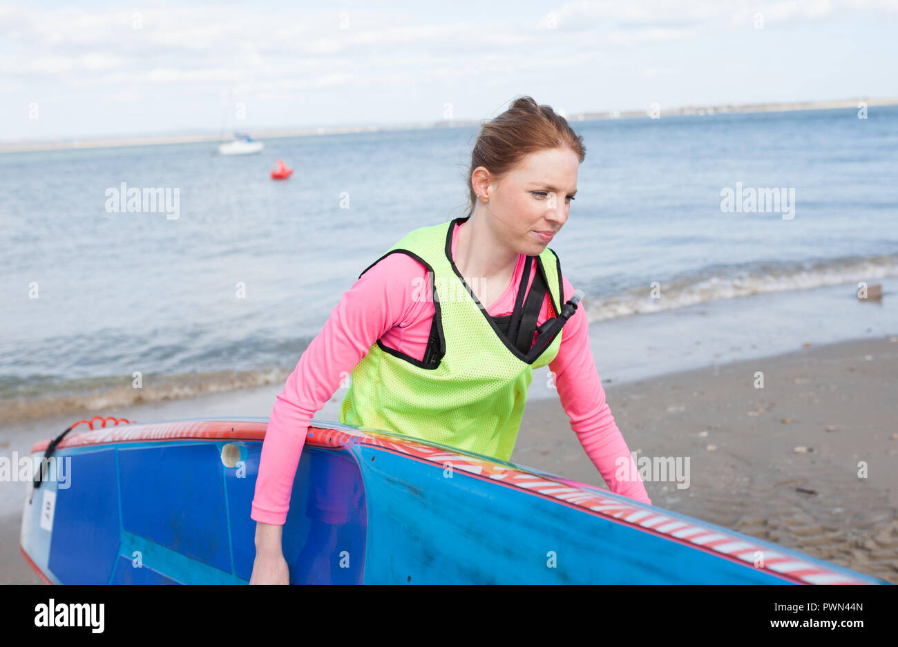 Girl walking with paddle board to a finish line Stock Photo - Alamy