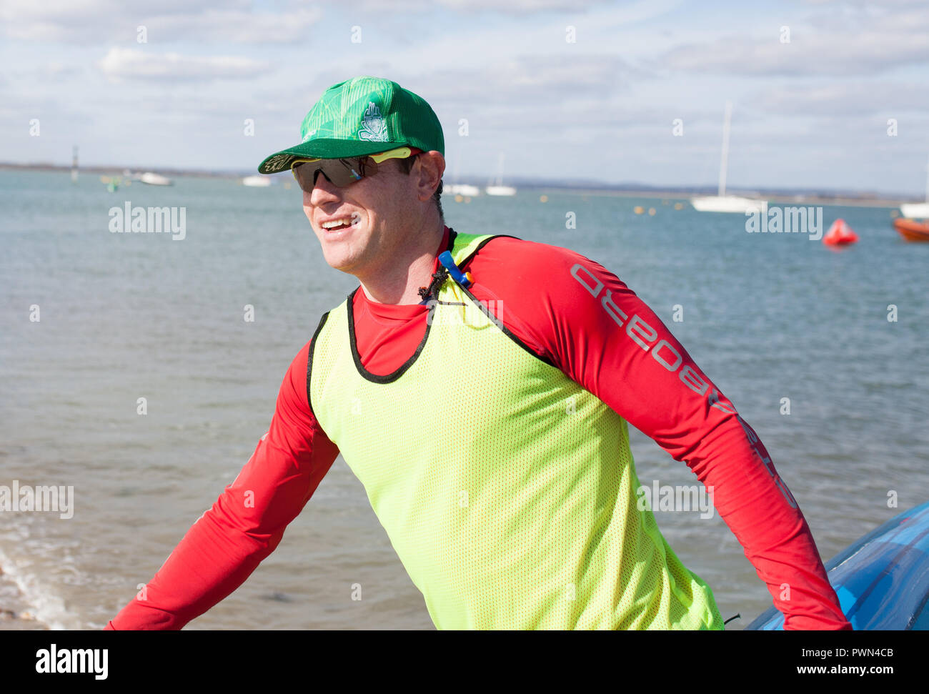 Man carrying paddle board to finish line Stock Photo - Alamy
