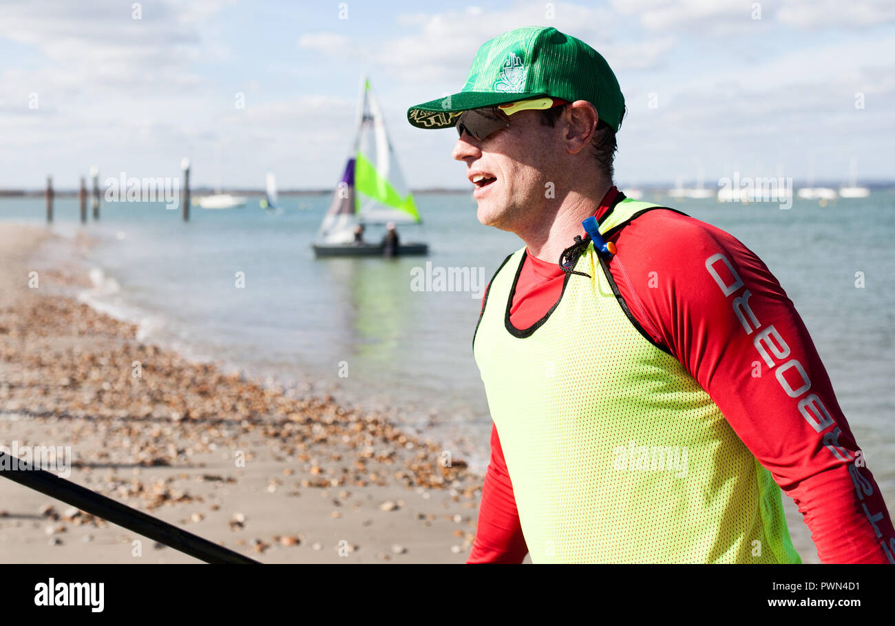 Man carrying paddle board to finish line Stock Photo - Alamy