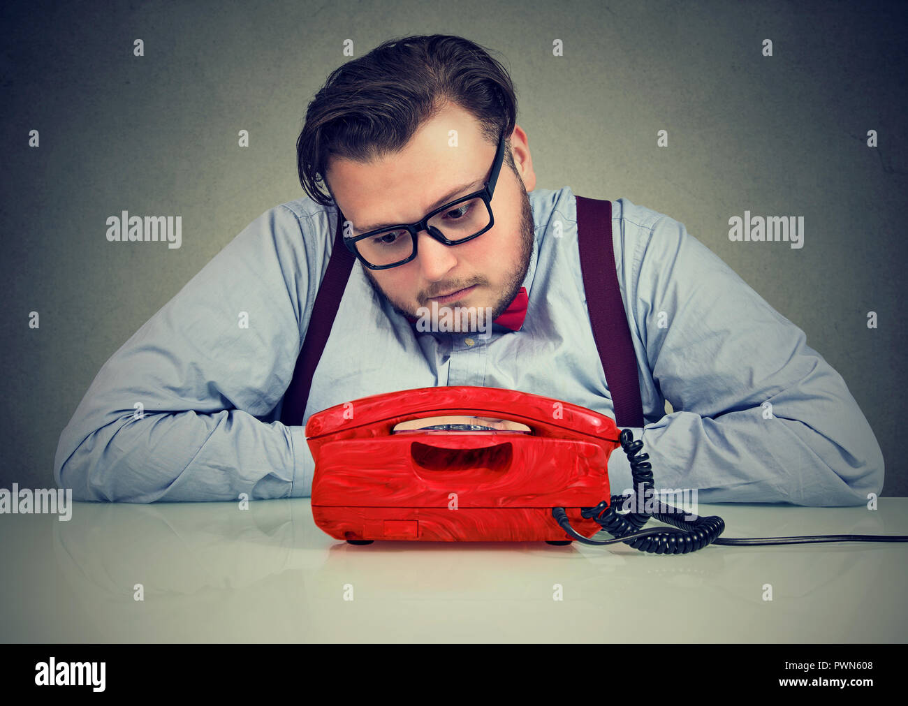Desperate sad man waiting for someone to call him Stock Photo - Alamy