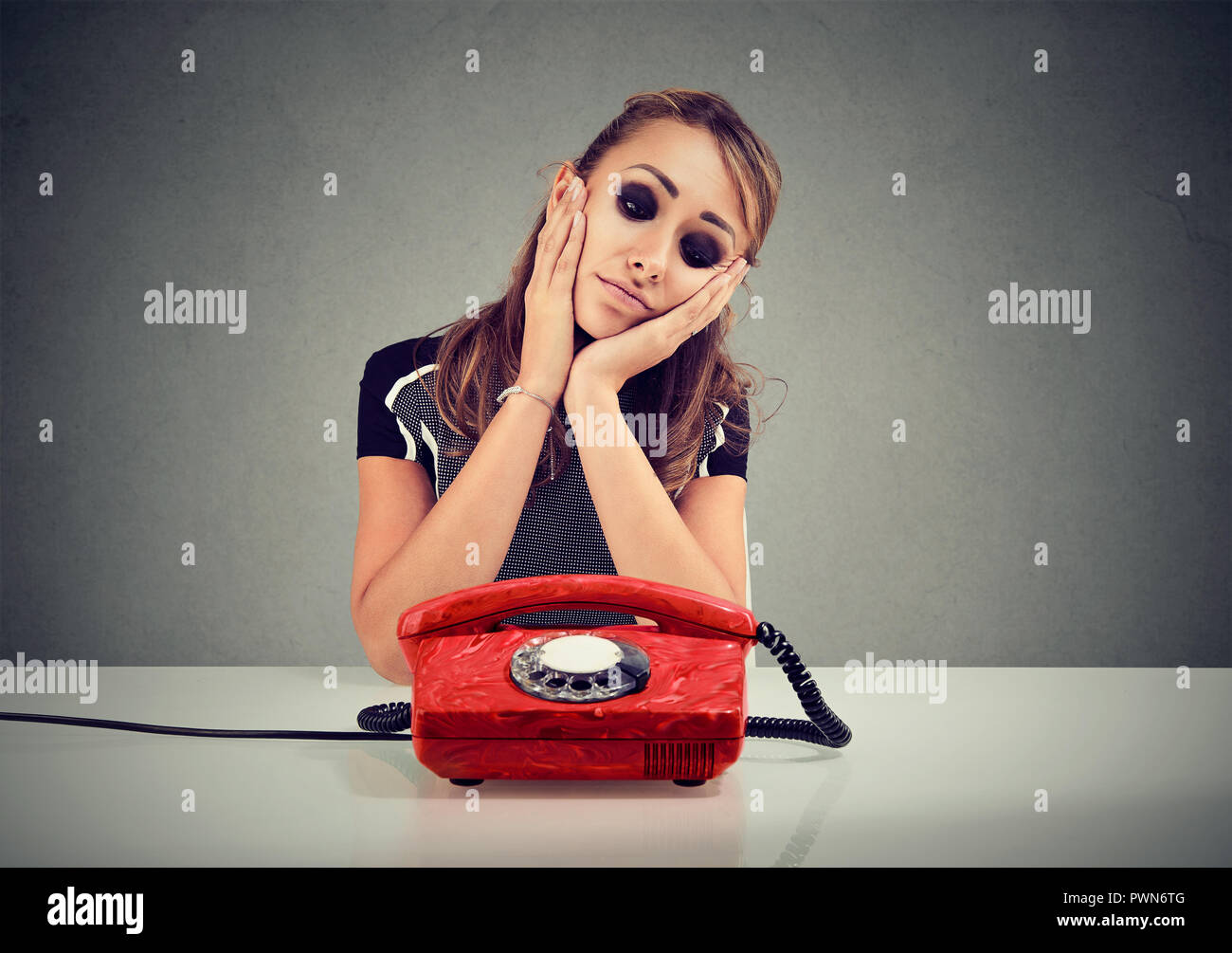 Desperate sad woman waiting for someone to call her Stock Photo - Alamy