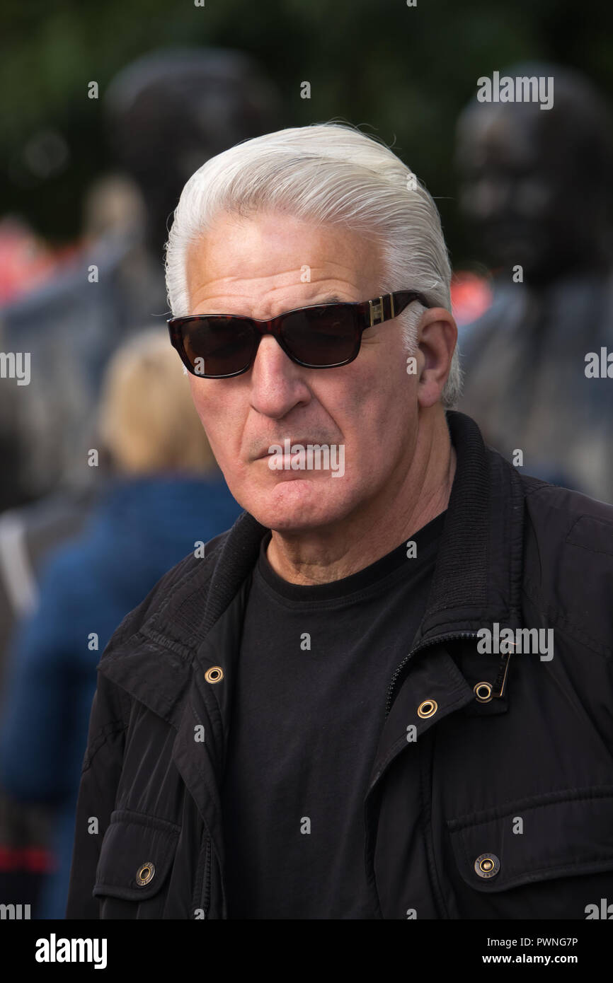Candid image of a distinguished looking man with silver hair wearing ...