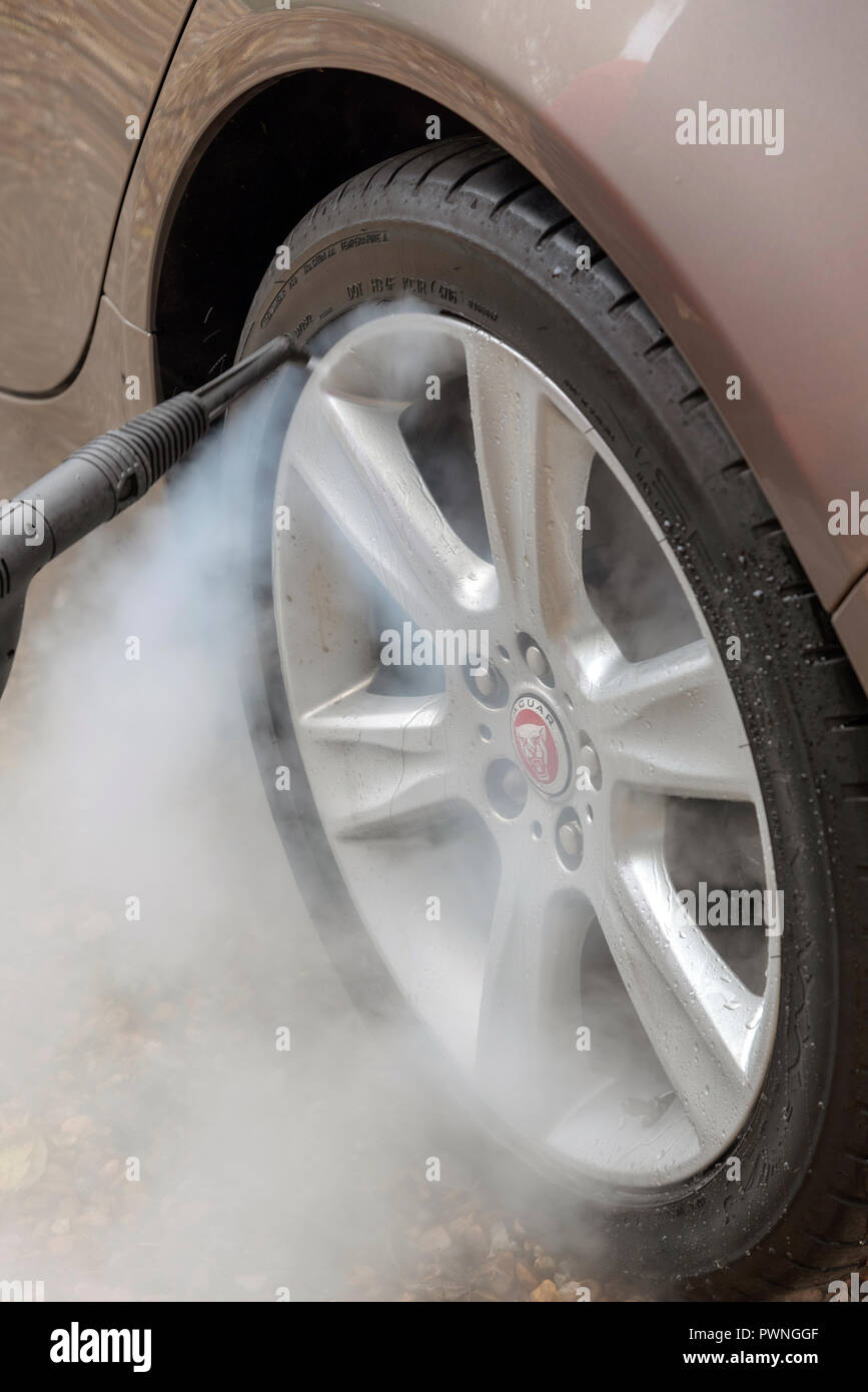 Man steam cleaning a luxury car on a home visiting valet service ...