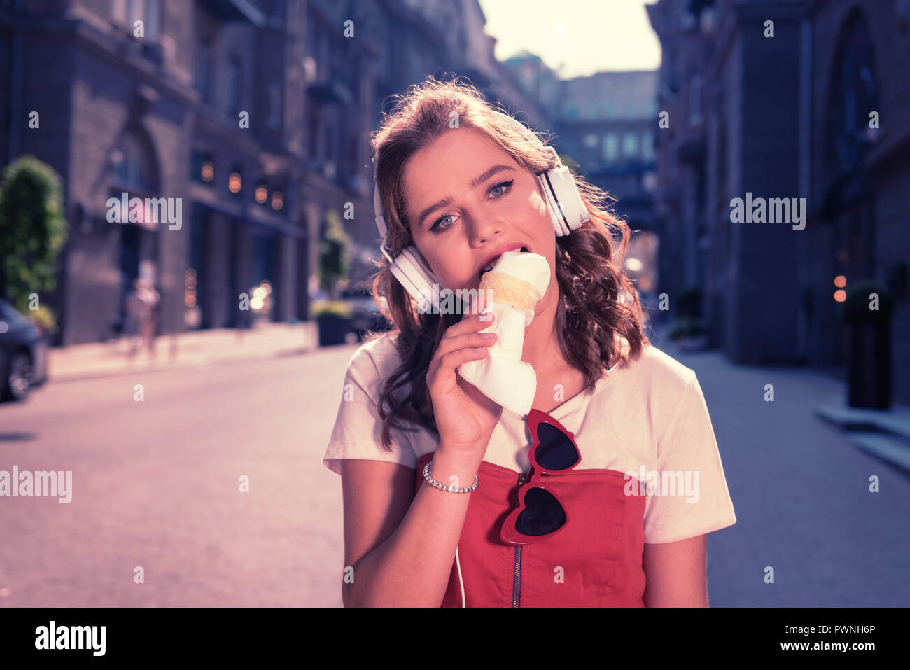 Good-looking girl with blue eyes enjoying the taste of delicious ice ...