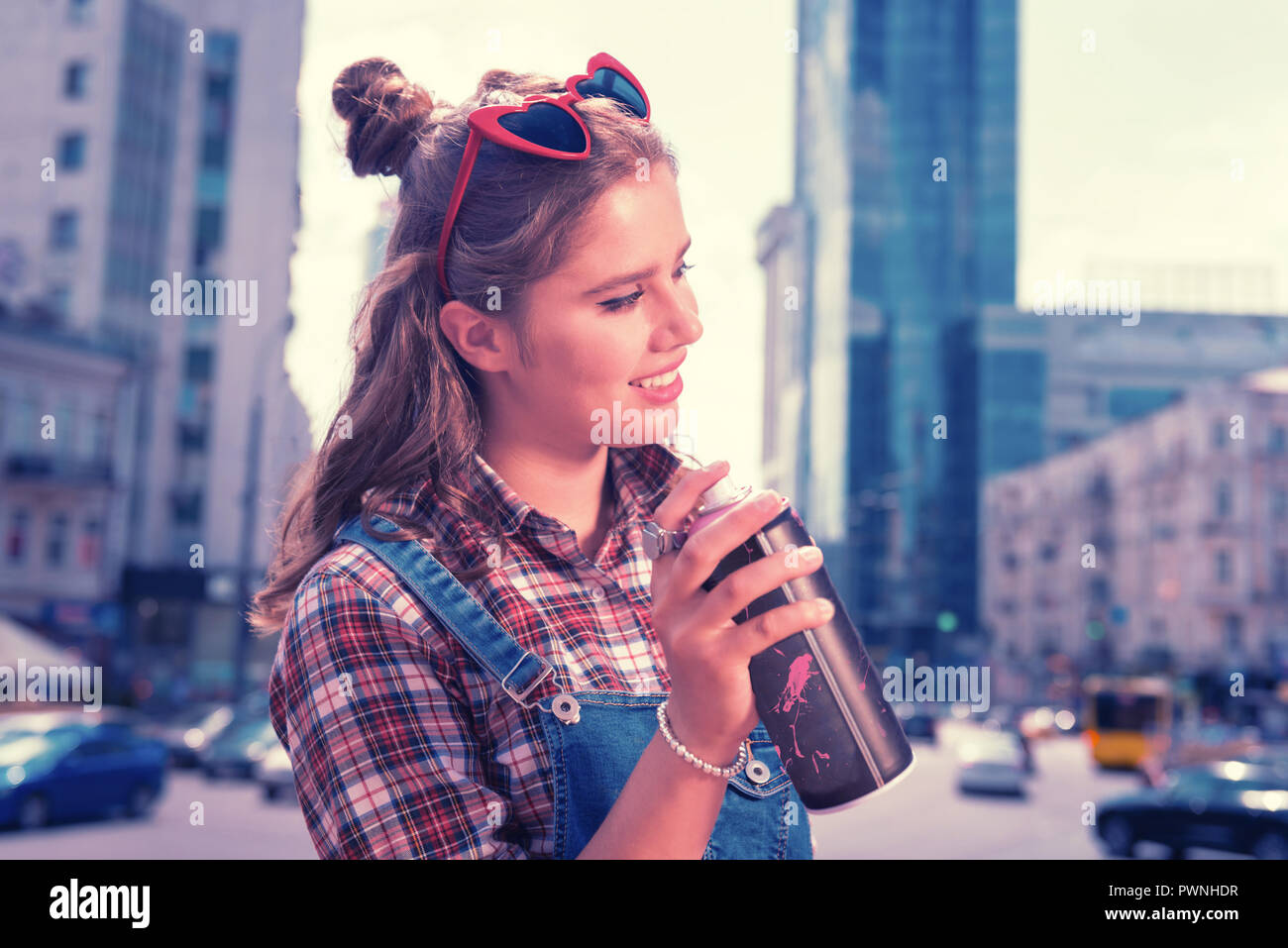 Modern beautiful fashionable girl drinking cold refreshing energy drink ...