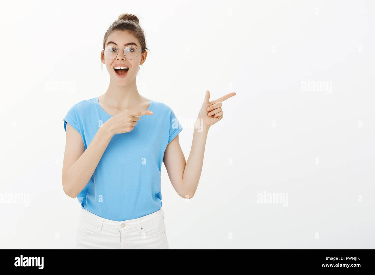 Portrait of good-looking happy young girl in glasses and bun, smiling ...