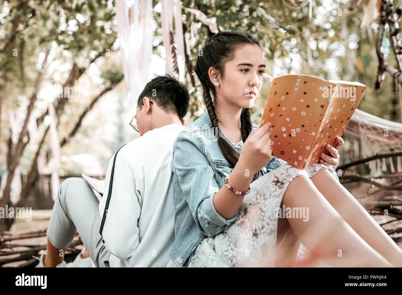 Upset charming female person reading her book Stock Photo - Alamy