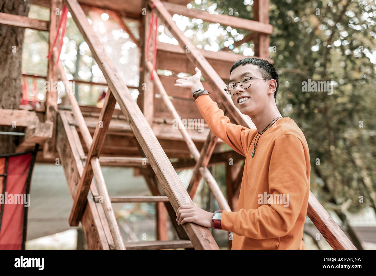 Portrait of happy man that pointing at tree house Stock Photo - Alamy