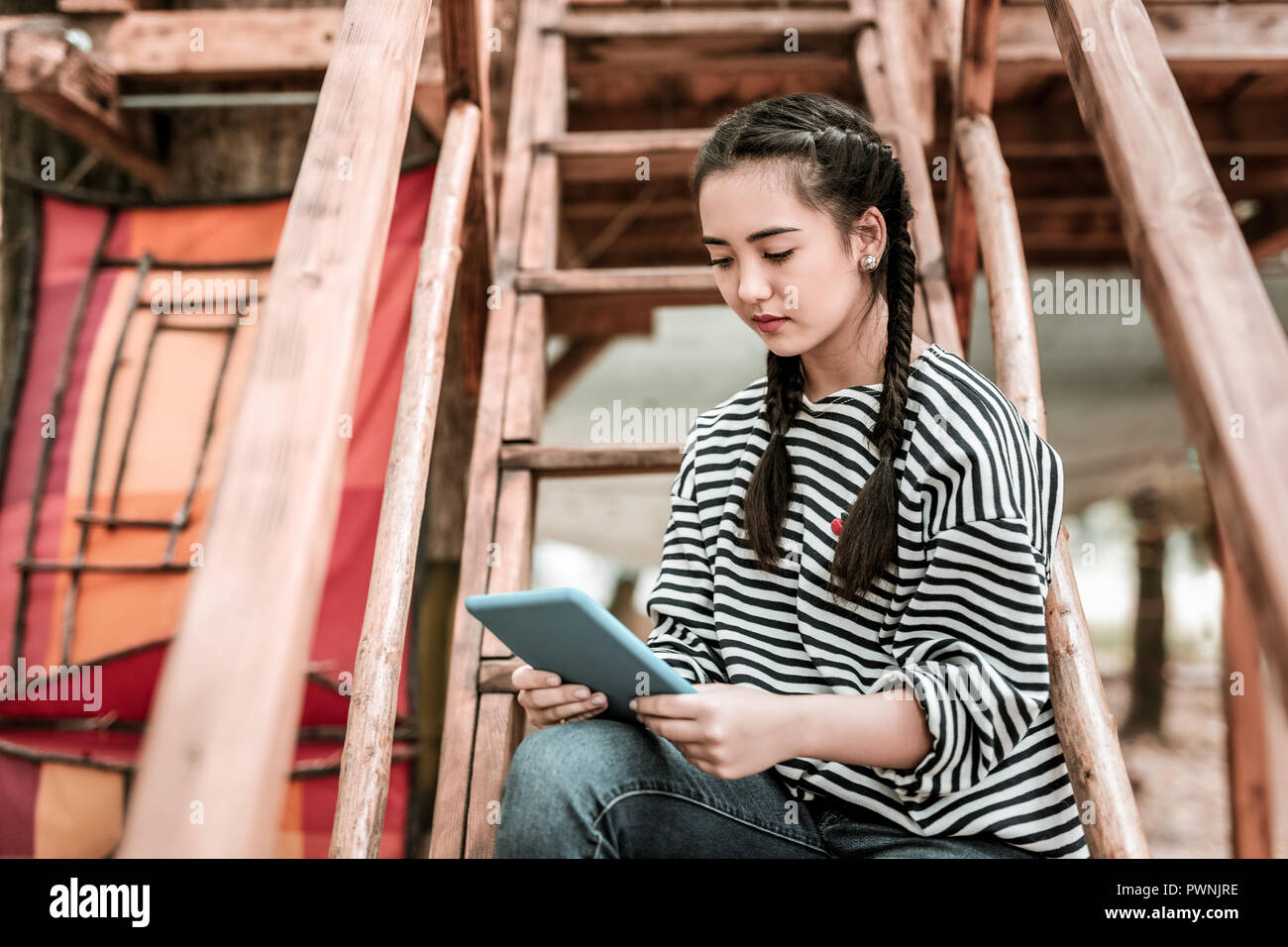 Attentive young female person staring at screen of tablet Stock Photo ...