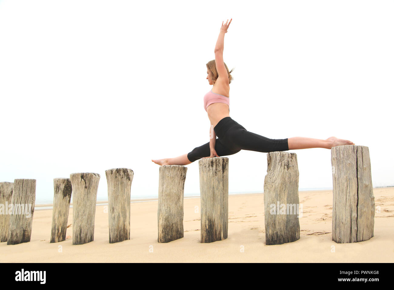 Young woman on the beach. Stretching Stock Photo - Alamy