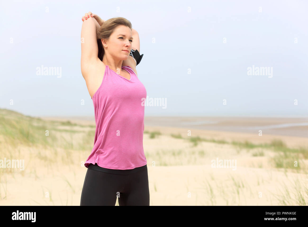 Young woman on the beach. Stretching Stock Photo - Alamy