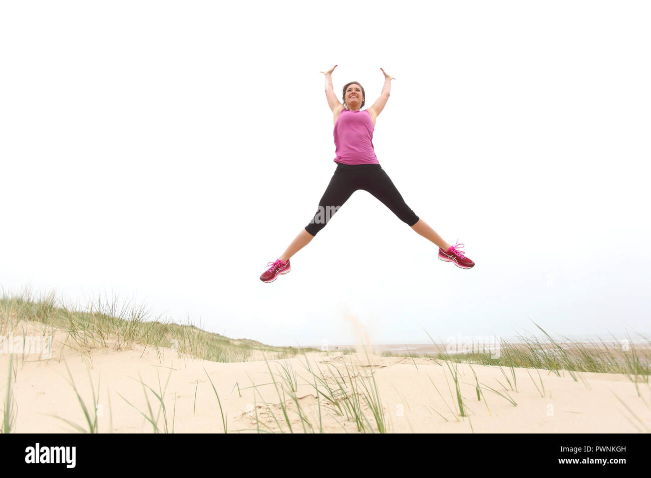 Young woman on the beach. Jump Stock Photo - Alamy