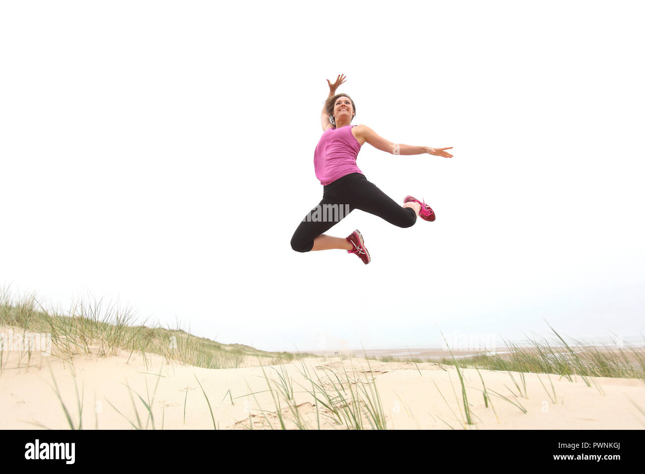 Young woman on the beach. Jump Stock Photo - Alamy