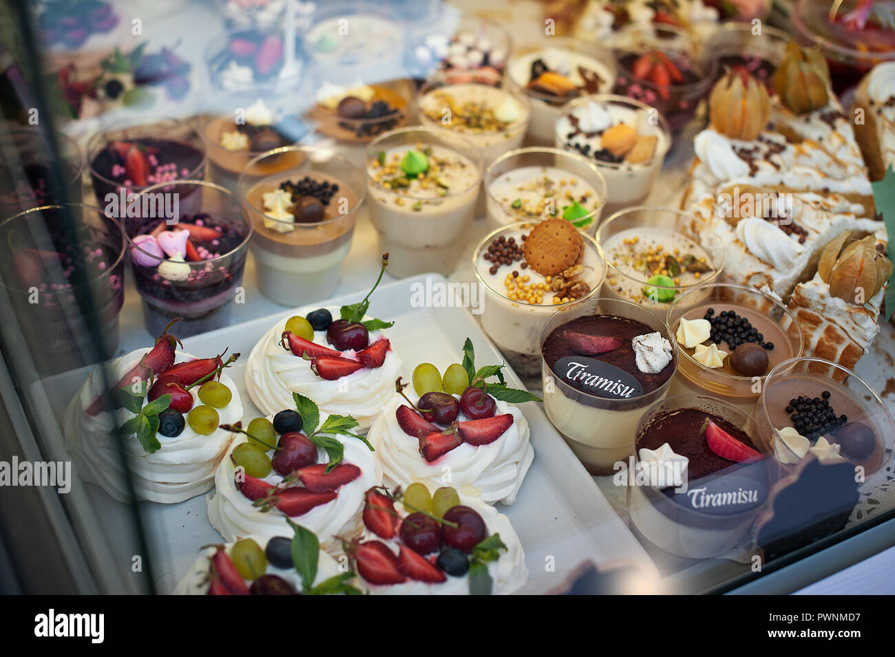 Showcase with many different desserts. Pavlova, tiramisu, cakes and ...