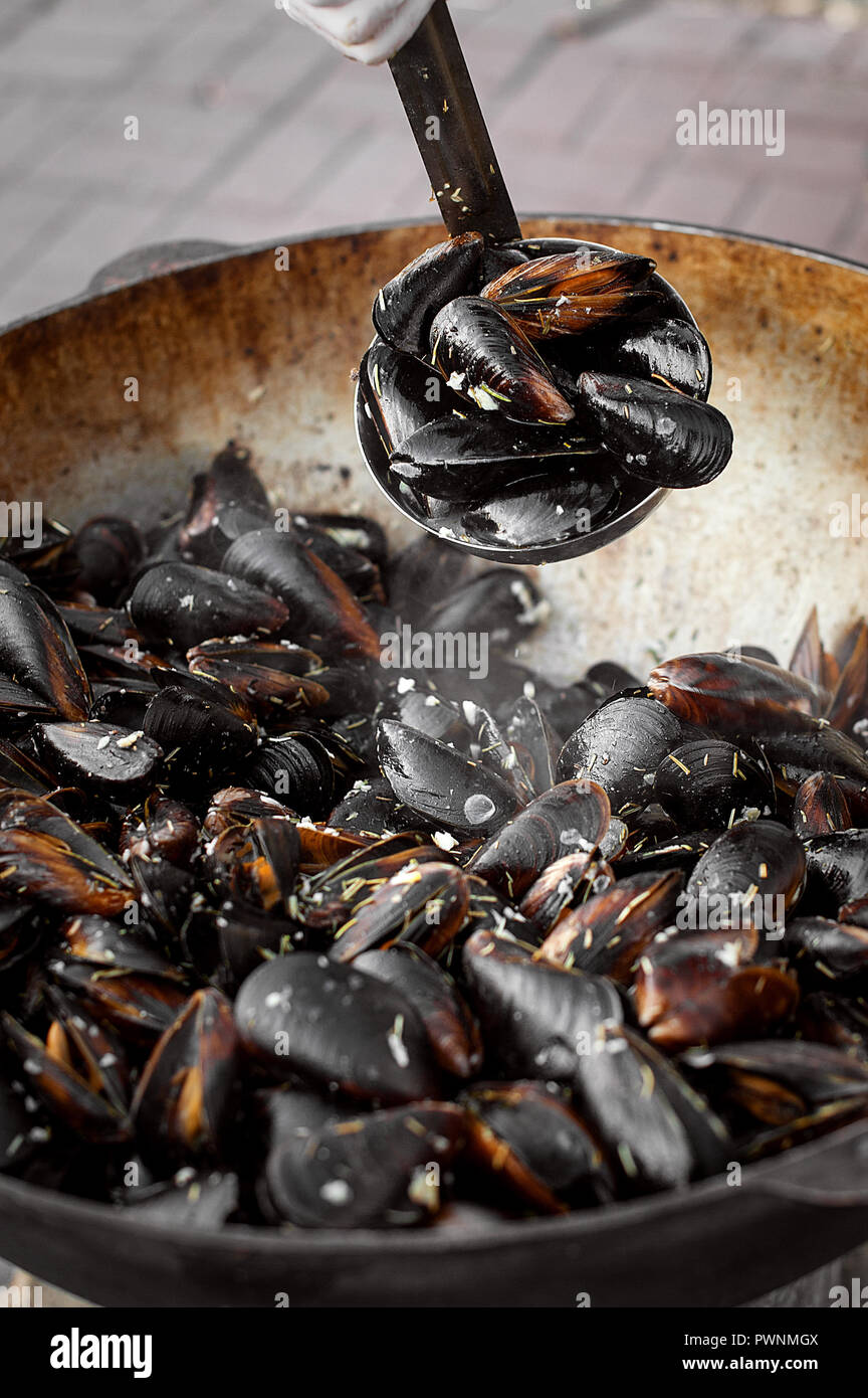 The process of preparing mussels in a large saucepan. Seafood with ...