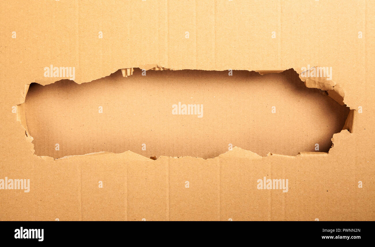 Cardboard with a hole - black background Stock Photo - Alamy