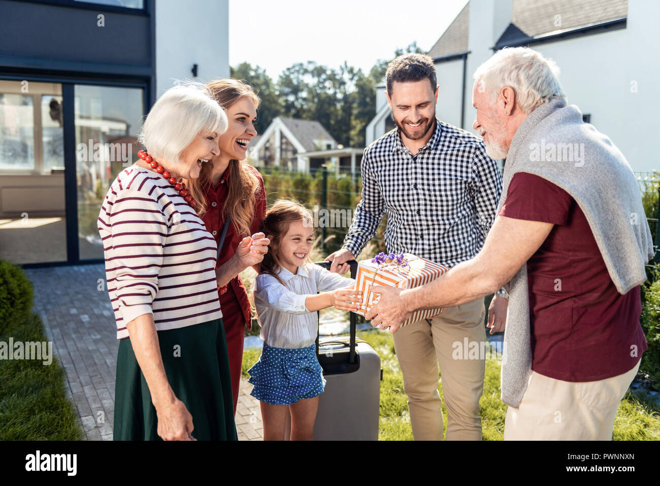 Cheerful senior people meeting their young children Stock Photo - Alamy