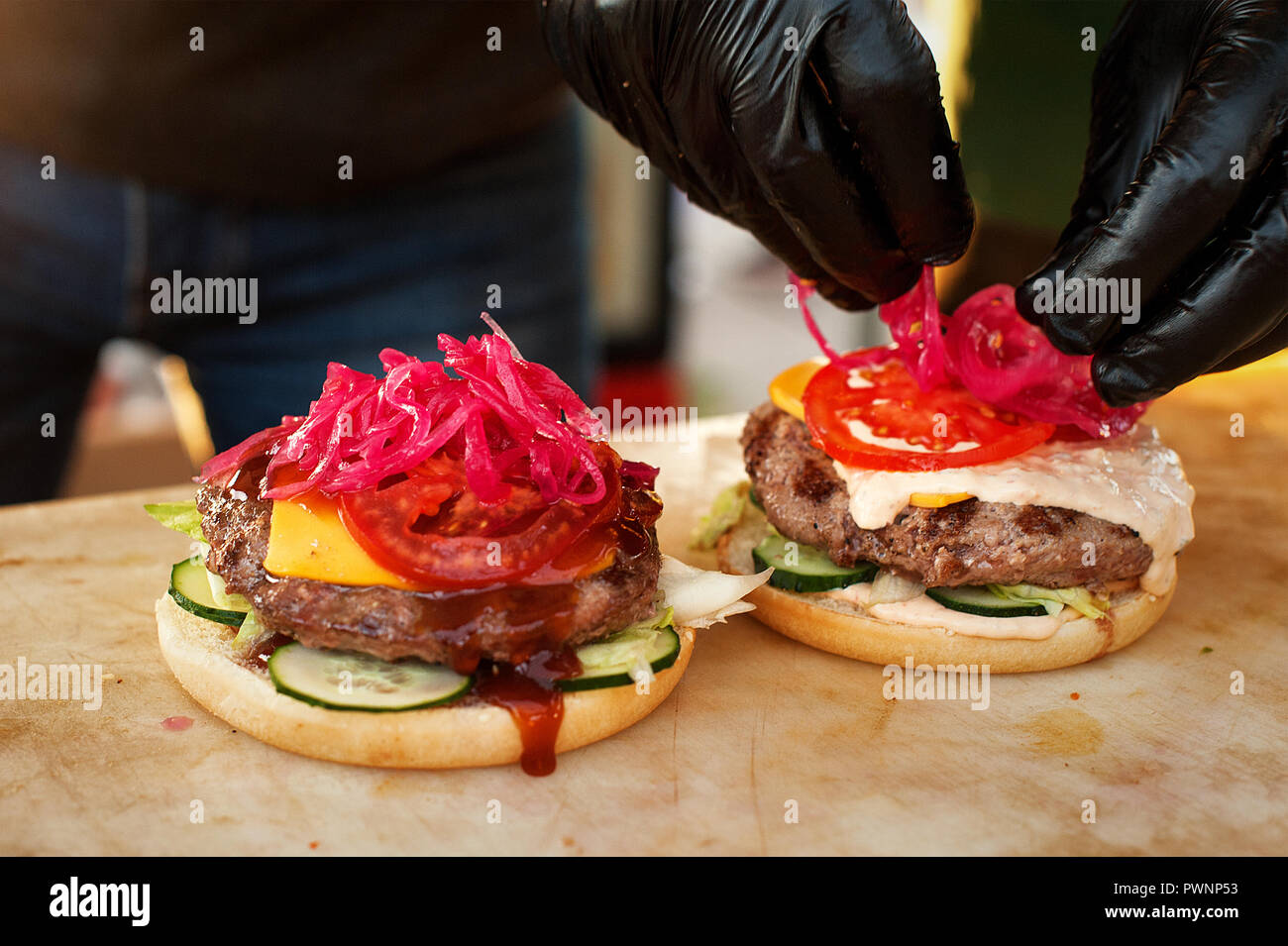 The chef prepares a burger in the open air kitchen. Street fast food ...