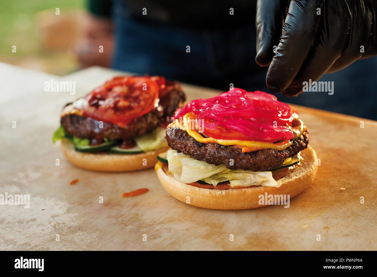 The chef prepares a burger in the open air kitchen. Street fast food ...