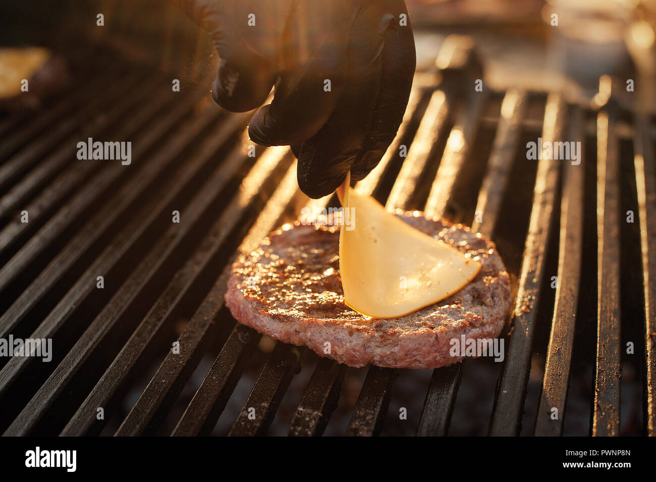 Chef making beef burger with cheese on open kitchen. Street fast food ...