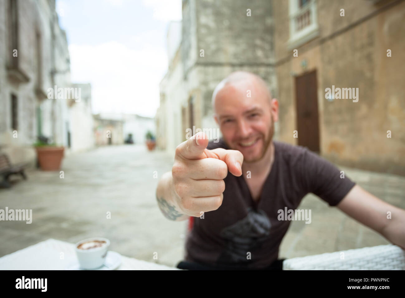 Specchia, Apulia, Italy - A man pointing at the camera with his finger ...