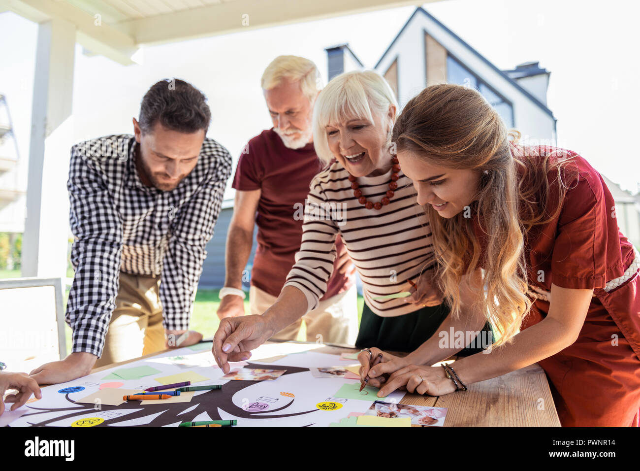 Positive delighted people doing their family tree Stock Photo - Alamy
