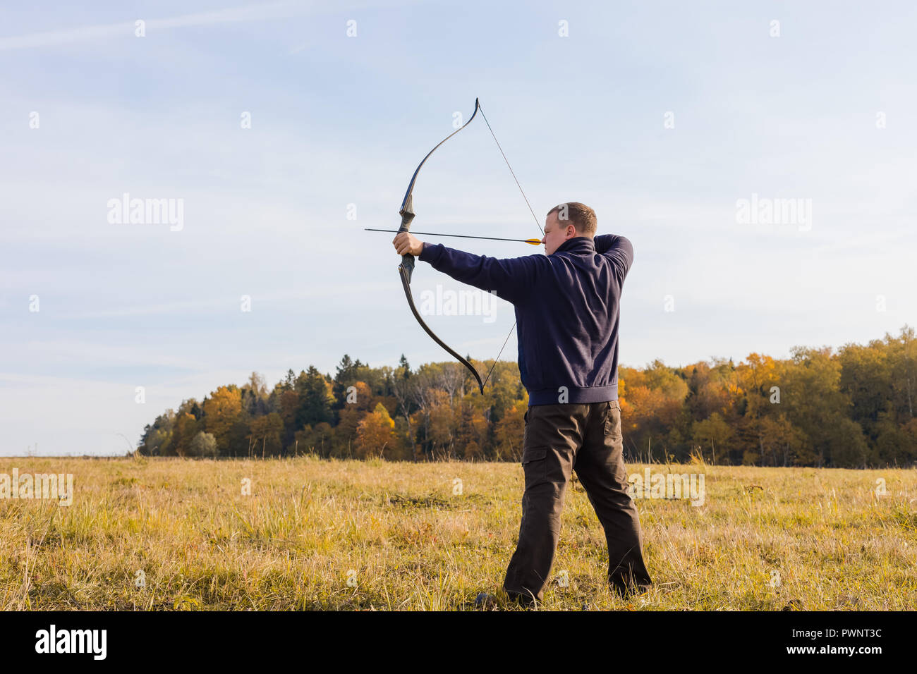 Athlete aiming at a target and shoots an arrow, toned Stock Photo - Alamy