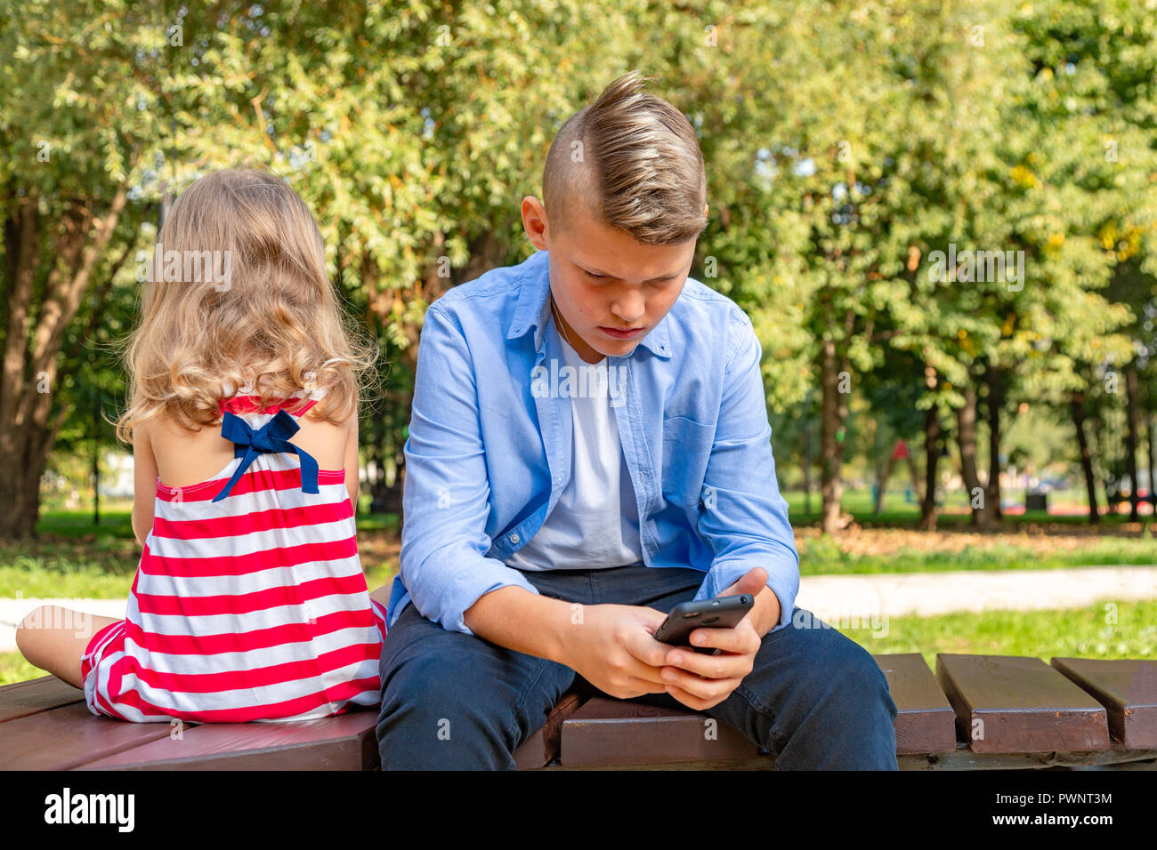 Group of busy kids looking at their phones texting sms and playing ...