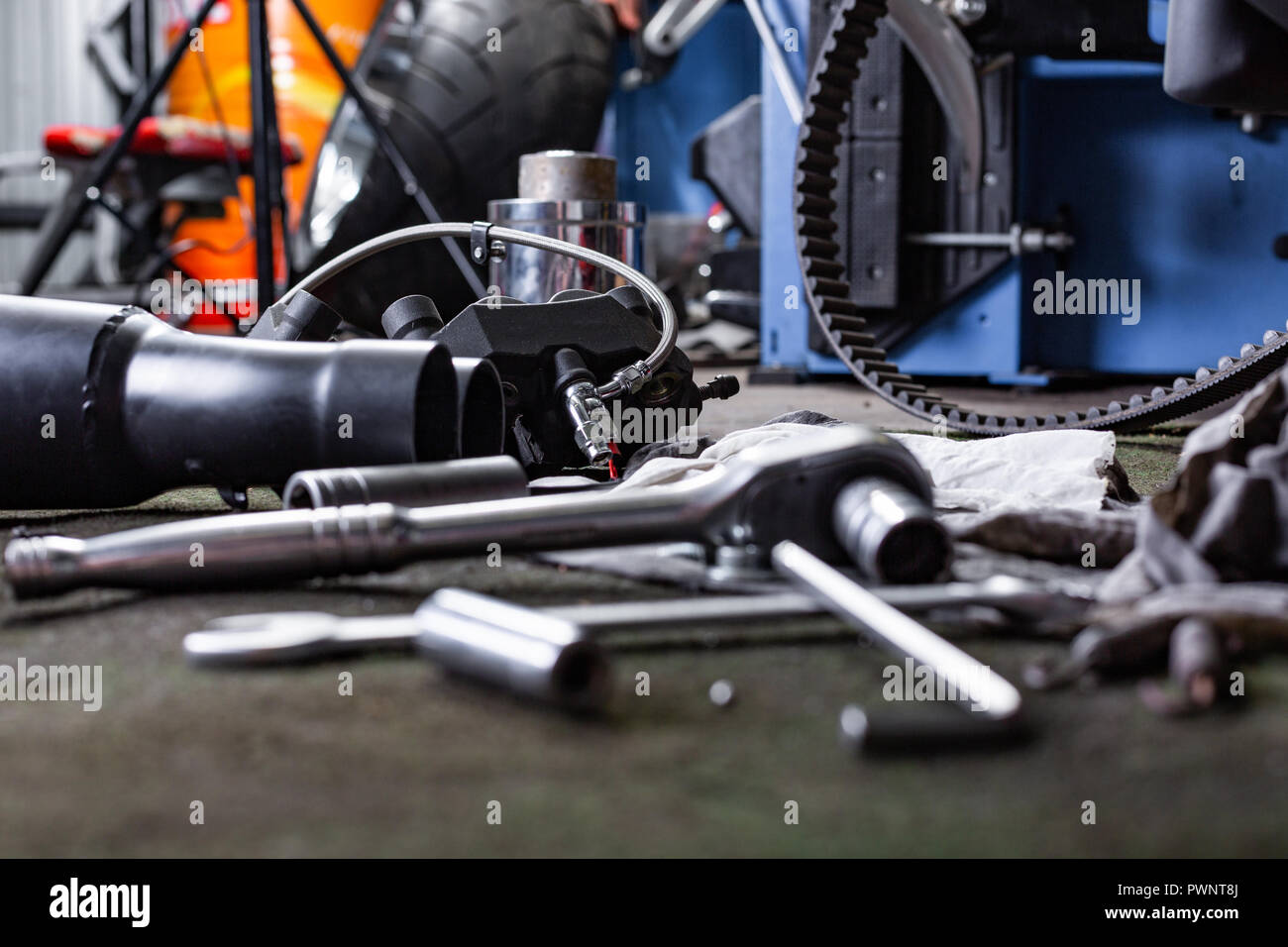 Row of screws and wrench tools on a floor in workshop near repaired old ...