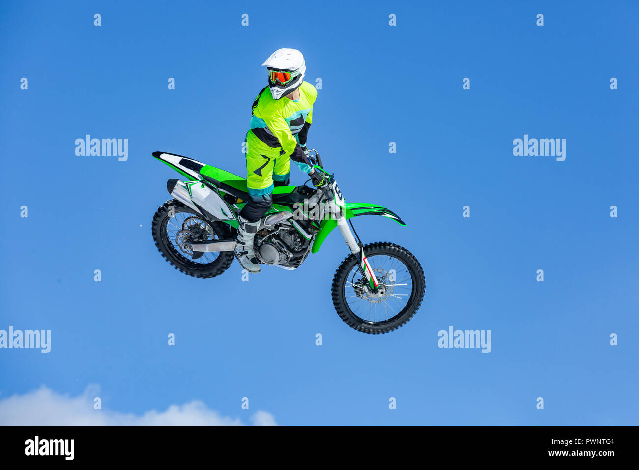 racer on a motorcycle in flight, jumps and takes off on a springboard ...