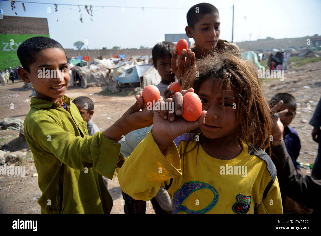 Peshawar. 17th Oct, 2018. Children play with eggs at a slum on the ...