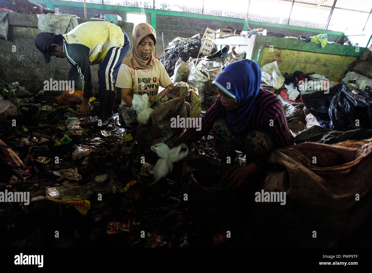 Workers sort waste collected from households and traditional markets ...