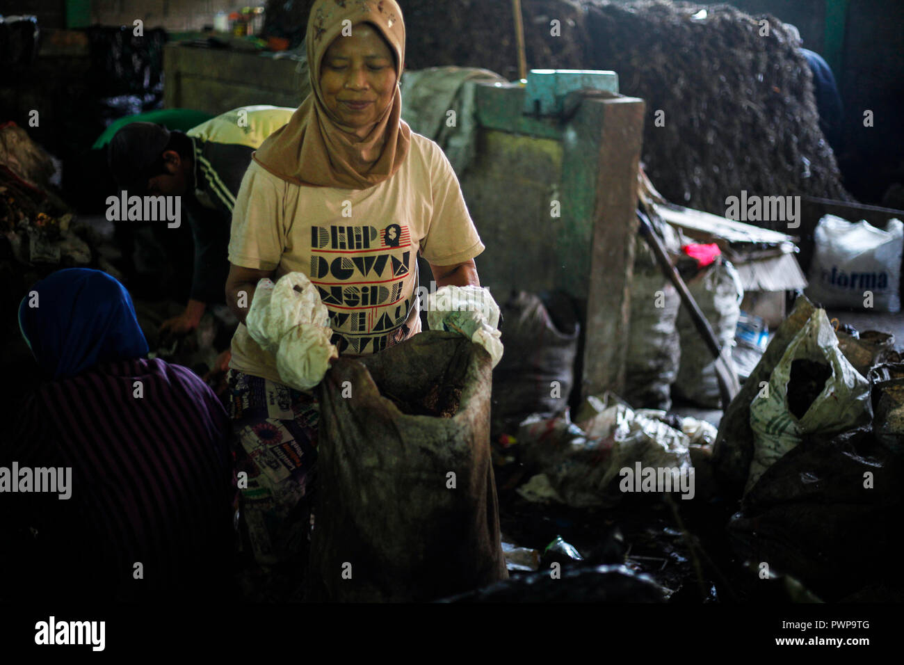 A female worker carry trash collected from households and traditional ...
