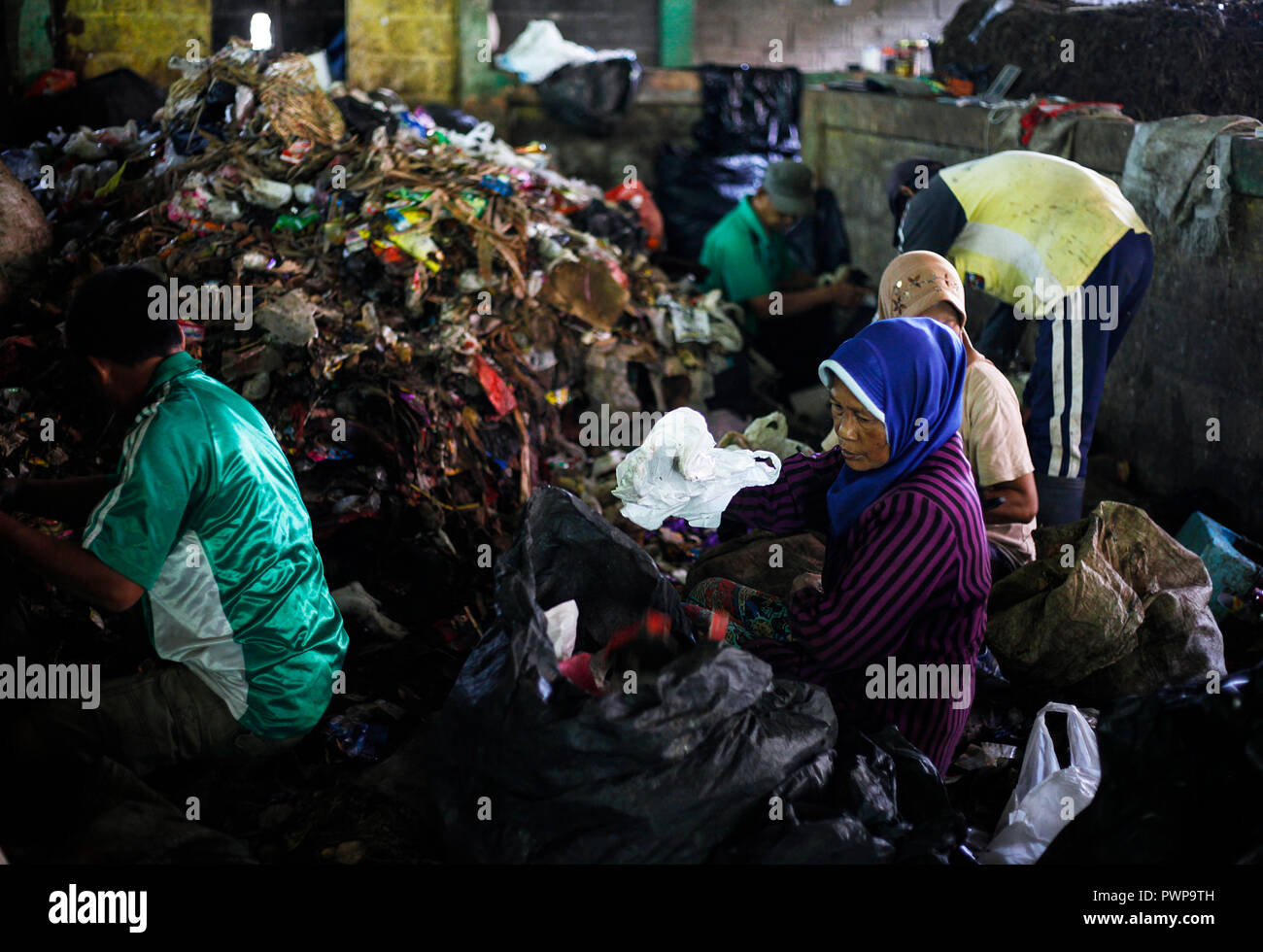 Workers sort waste collected from households and traditional markets ...