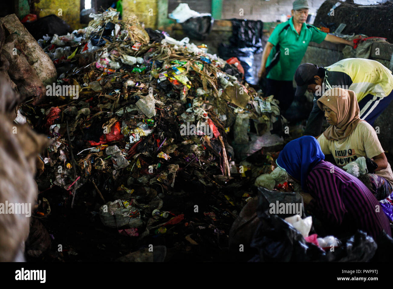 Workers sort waste collected from households and traditional markets ...