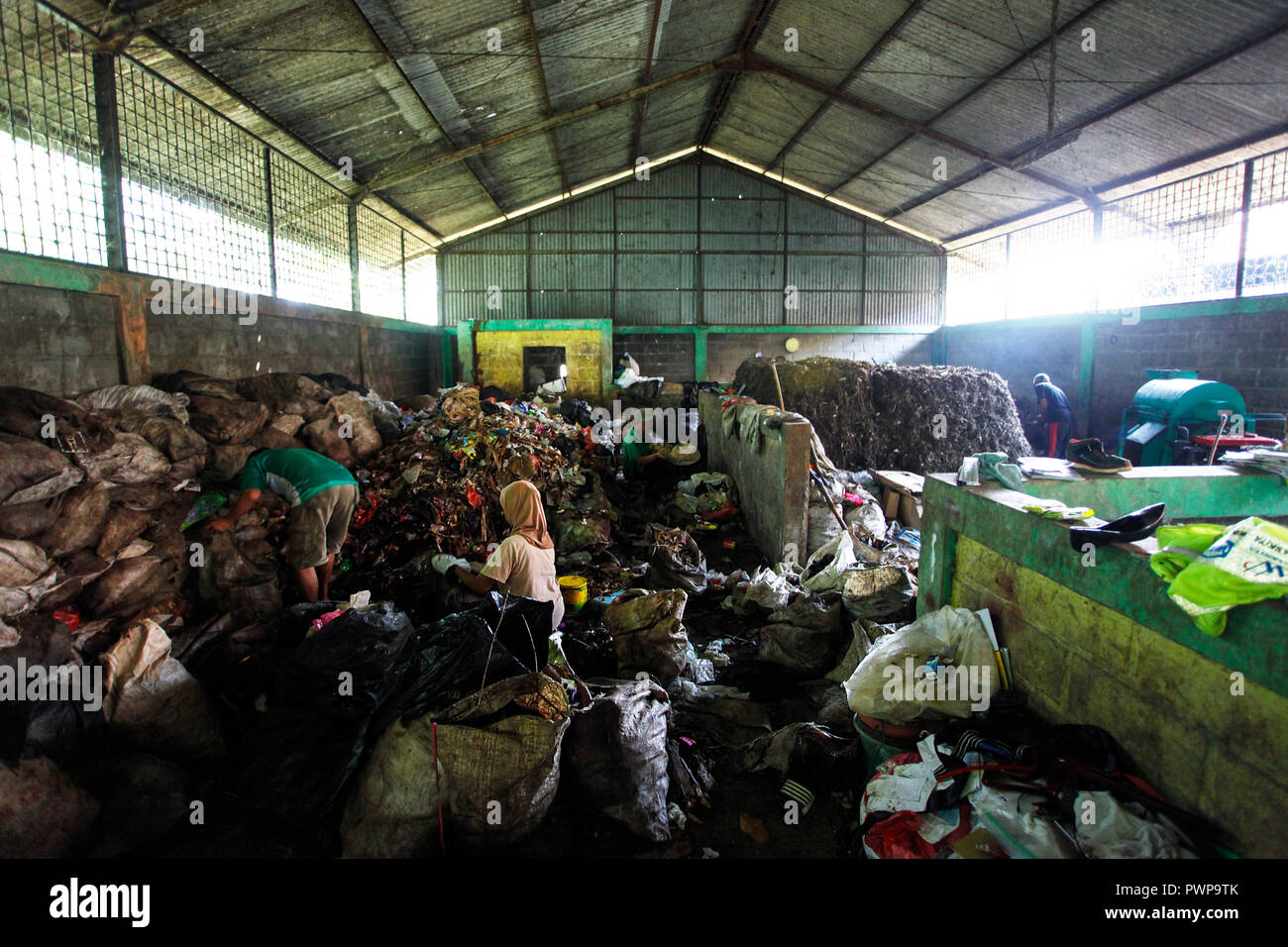 Workers sort waste collected from households and traditional markets ...