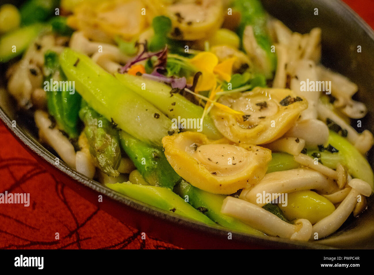 Wok-fried abalone with mixed mushrooms and black truffle paste Stock ...