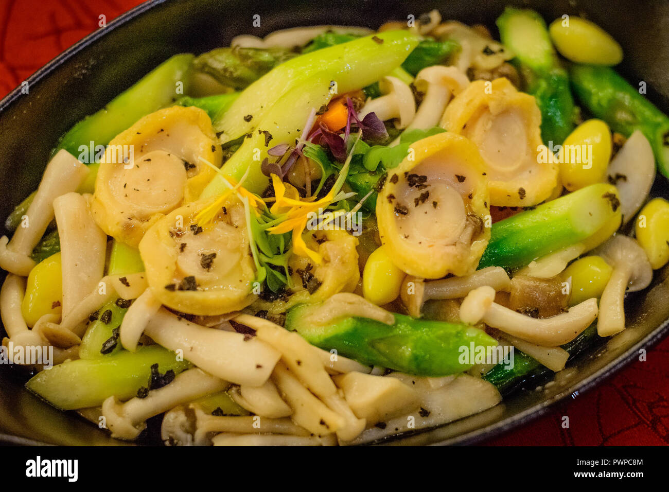 Wok-fried abalone with mixed mushrooms and black truffle paste Stock ...