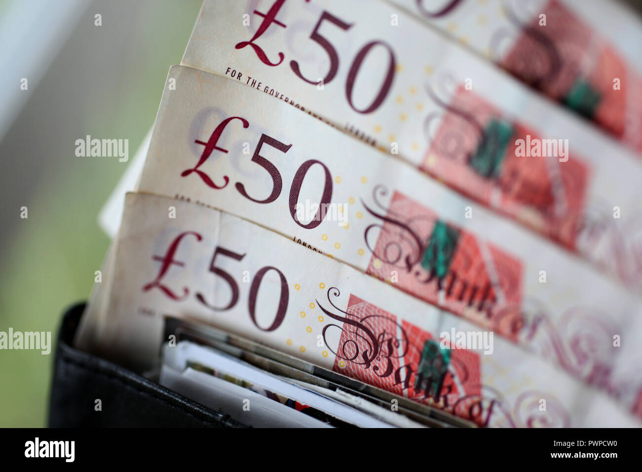 A selection of £50 notes along with £10 and £5 notes in a wallet in ...