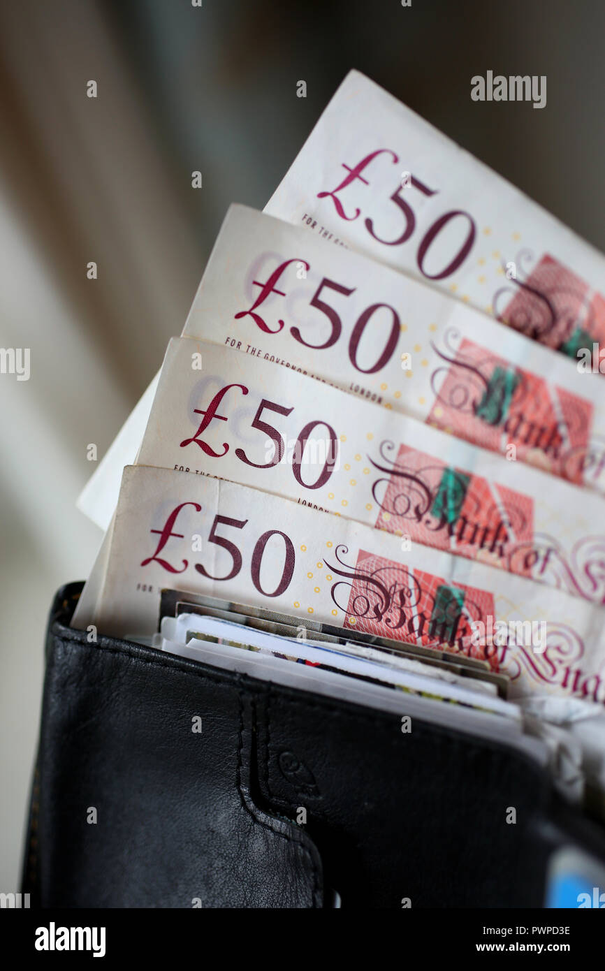 A selection of £50 notes along with £10 and £5 notes in a wallet in ...