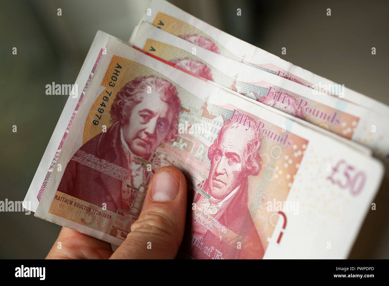 A selection of £50 notes along with £10 and £5 notes in a wallet in ...
