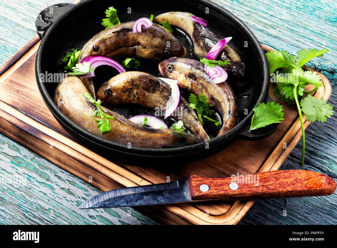 Fresh sea fish in a frying pan on the kitchen table.Gobiidae fish Stock ...