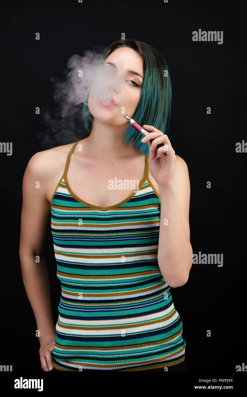 Young woman vape an electronic cigarette Stock Photo - Alamy