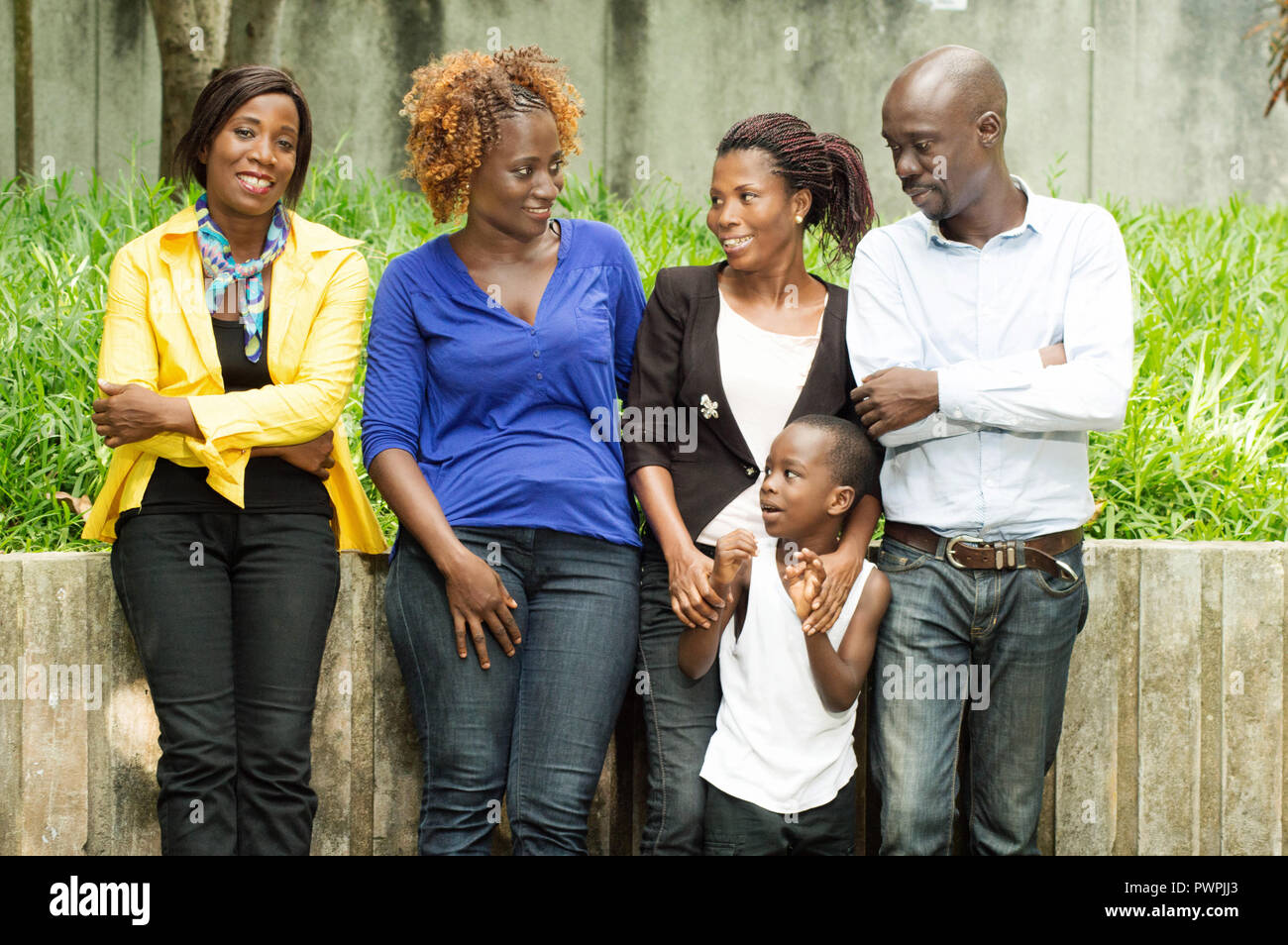 These people gathered in the park against the wall , enjoying the nice ...